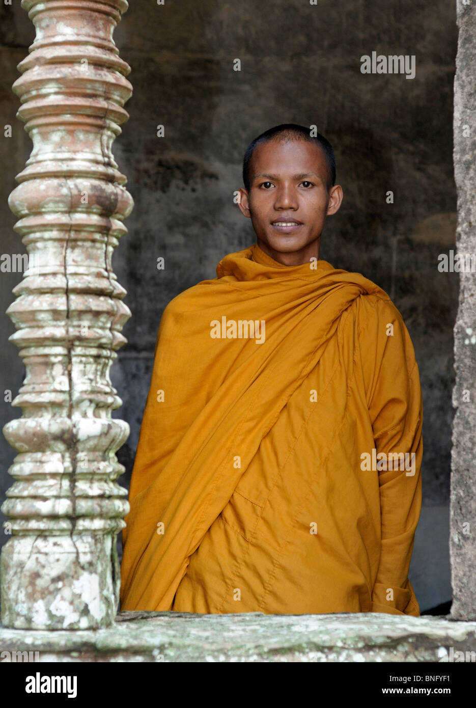 Buddhist monk standing in stone window of Angkor Wat, Cambodia Stock ...