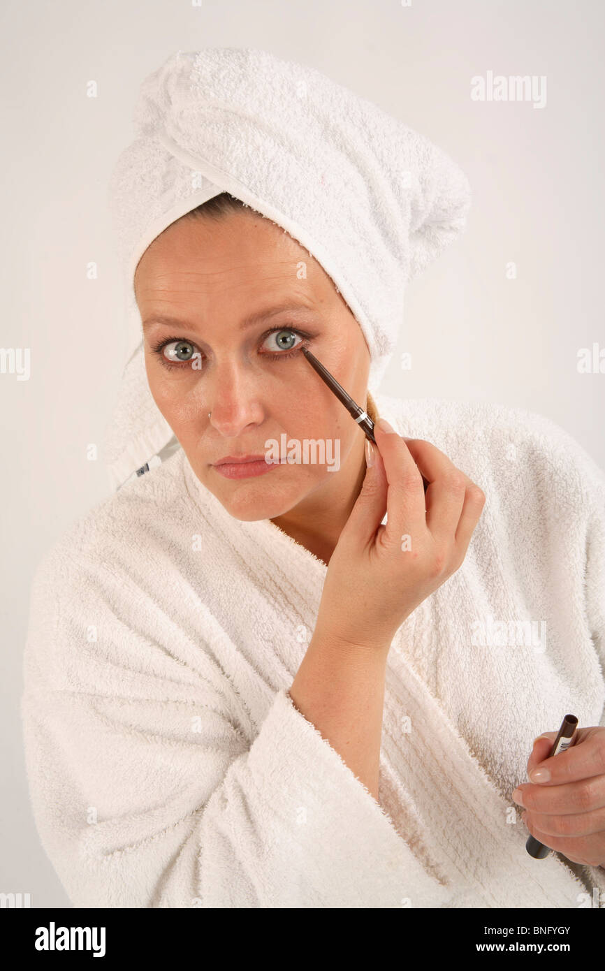 Woman applying make-up Stock Photo - Alamy