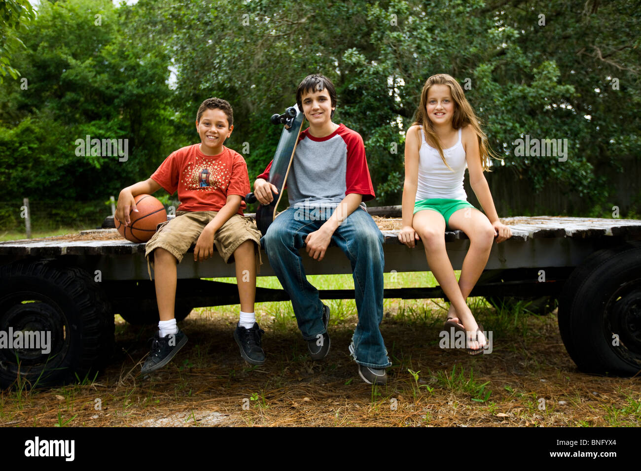 Three friends sitting in a park Stock Photo - Alamy