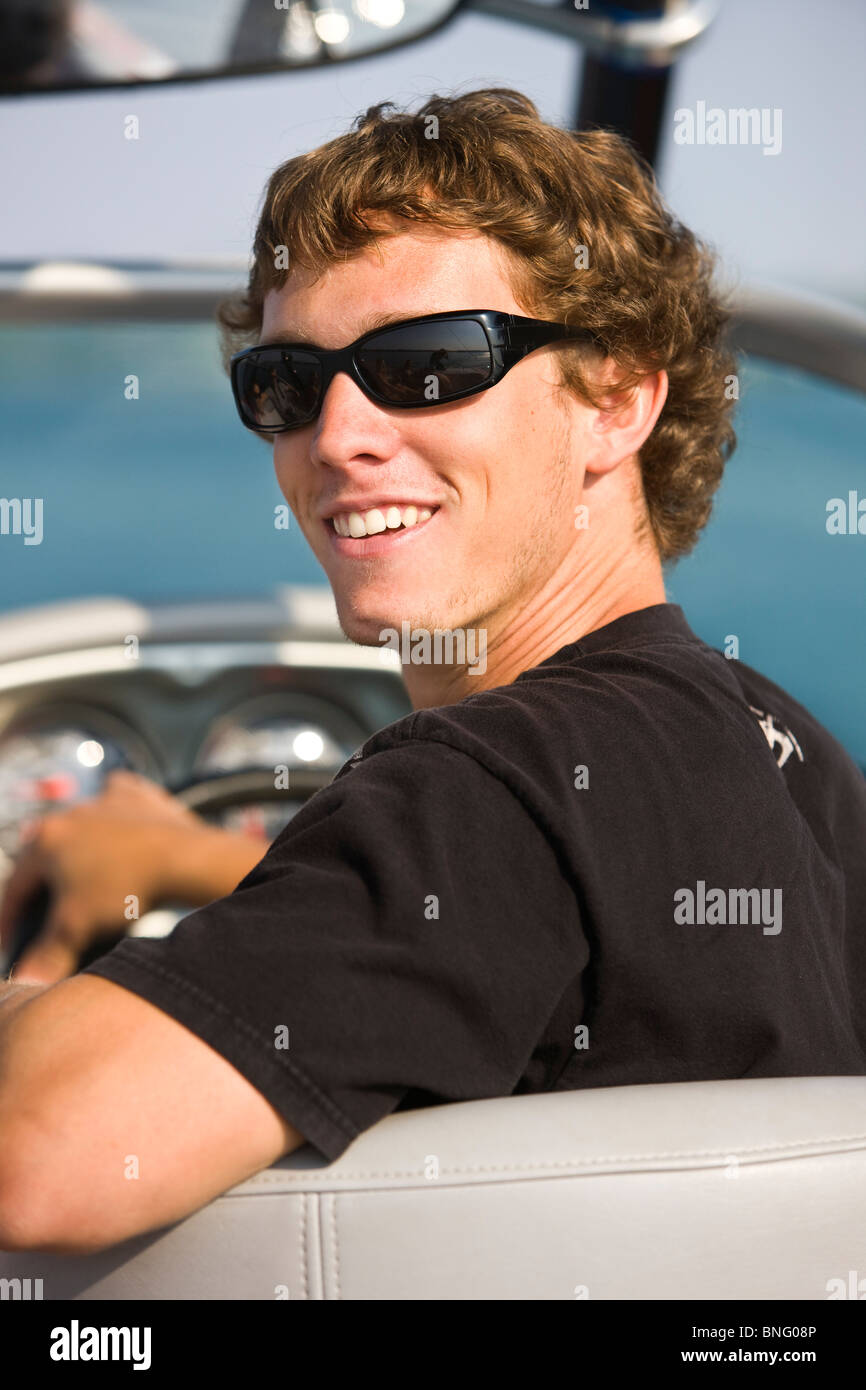 Young man sitting on motorboat hi-res stock photography and images - Alamy