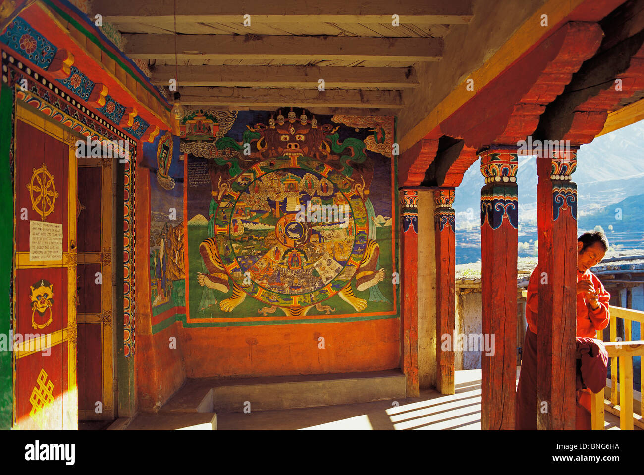 A monk works on the balcony of the Tibetan gompa or shrine at Jharkot ...