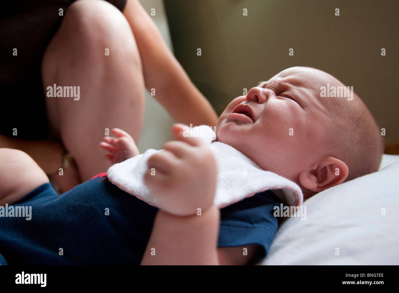 Baby crying with its mother beside him Stock Photo - Alamy