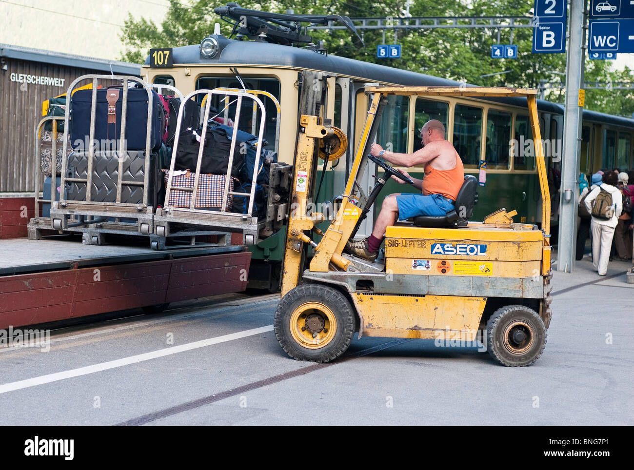 Fork-lift truck driver loading luggage onto a railway truck in Wengen ...