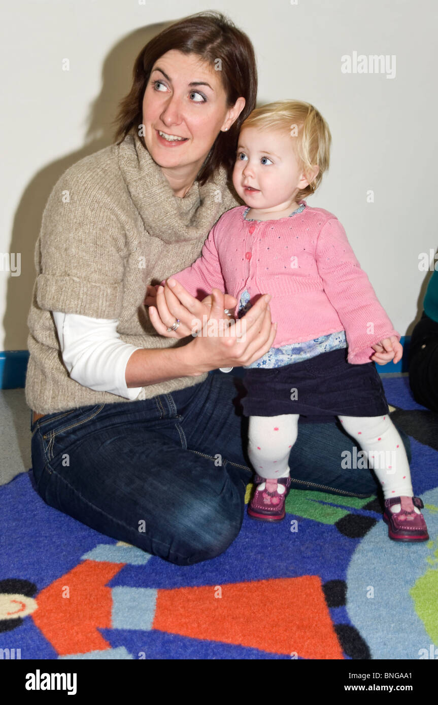 Vertical portrait of a young mum with her baby daughter at a 'Parent ...