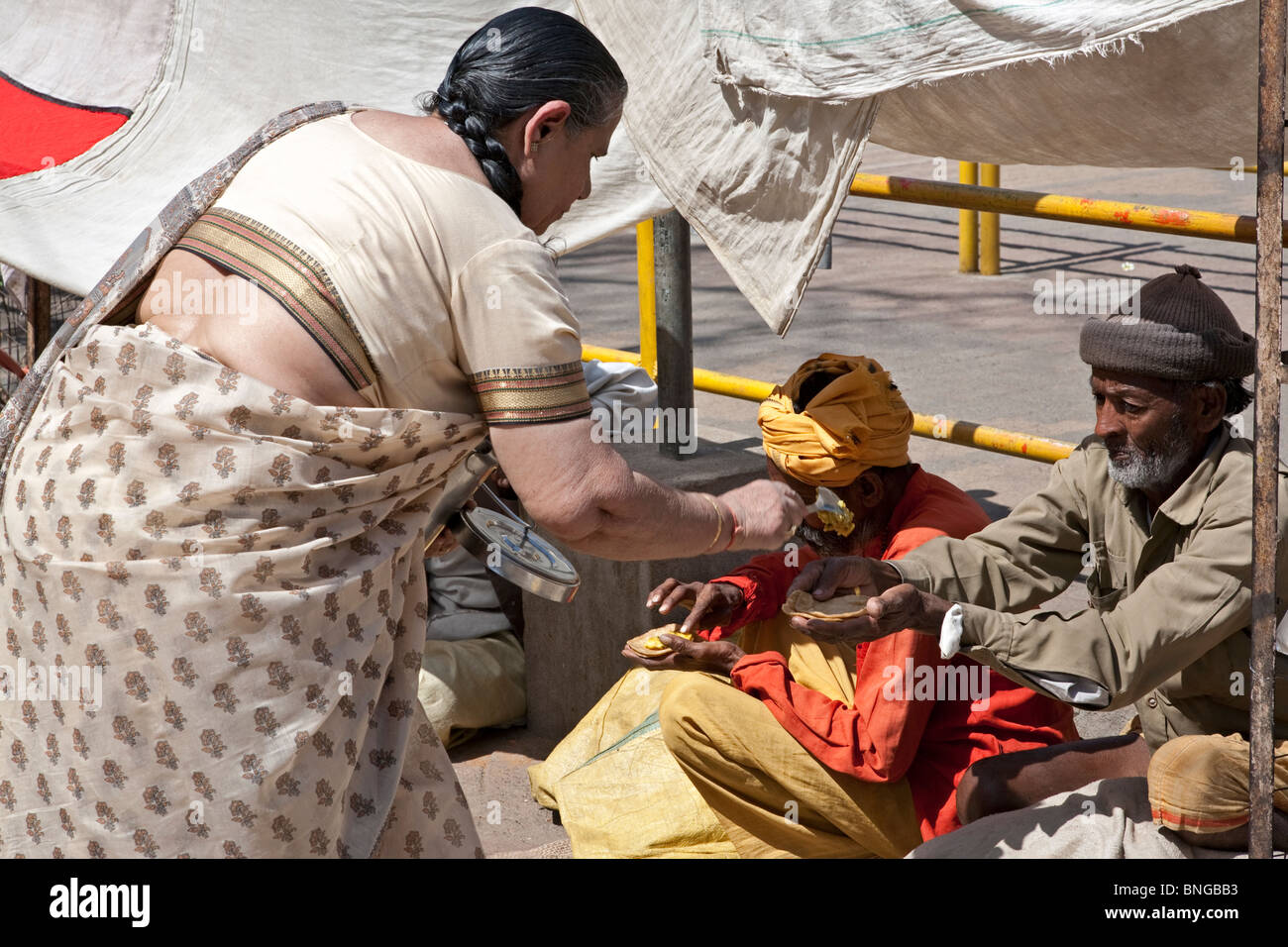 Woman giving food to beggars. Orchha. India Stock Photo - Alamy