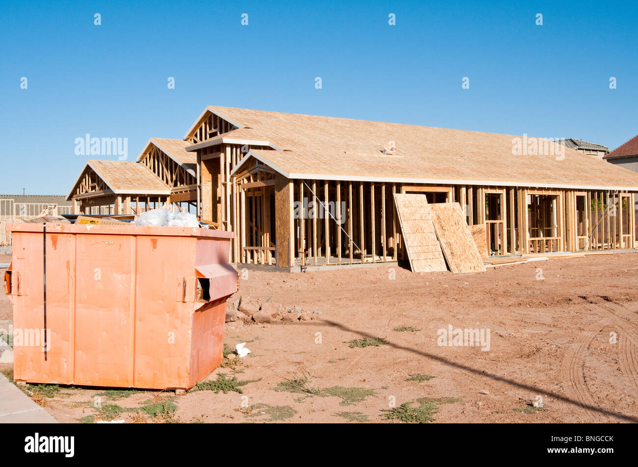 Construction trash is collected in a dumpster on the site of a new wood ...