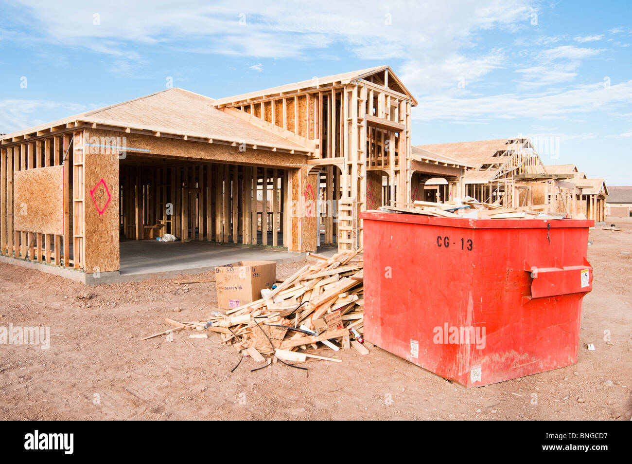 Construction trash is collected in a dumpster on the site of a new wood ...