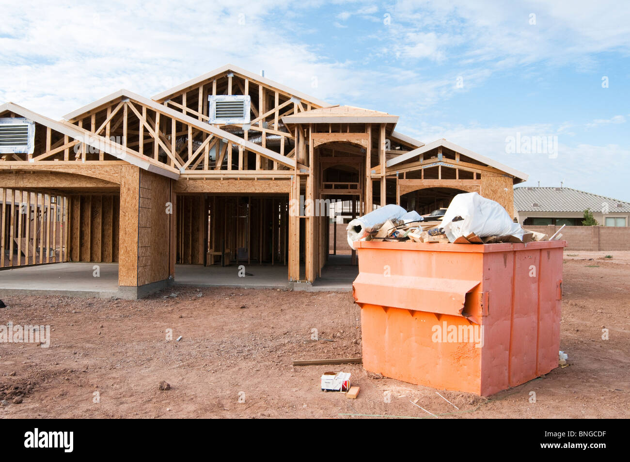 Construction trash is collected in a dumpster on the site of a new wood ...
