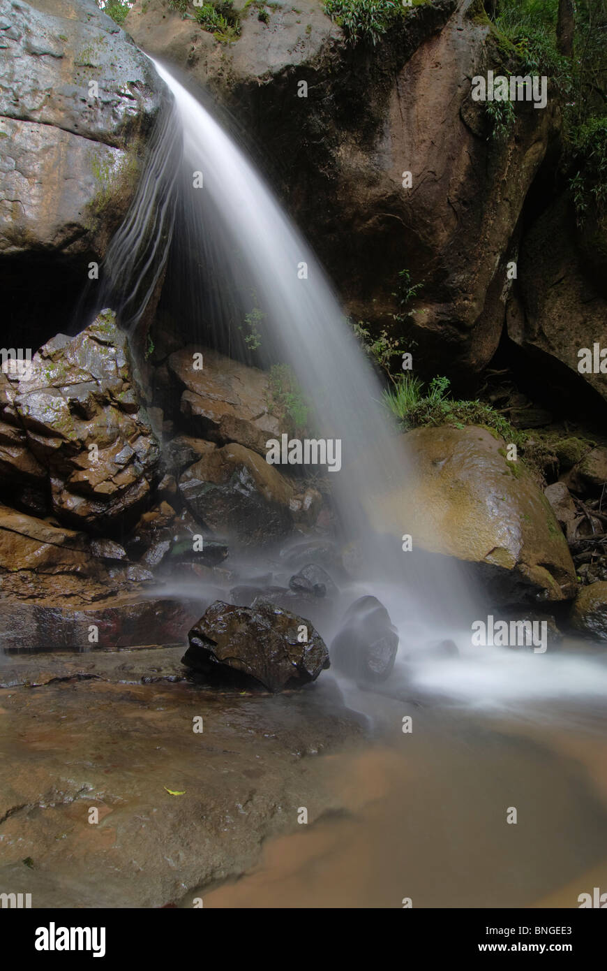 Low angle of a small cascade of water flowing over rocks into plunge ...