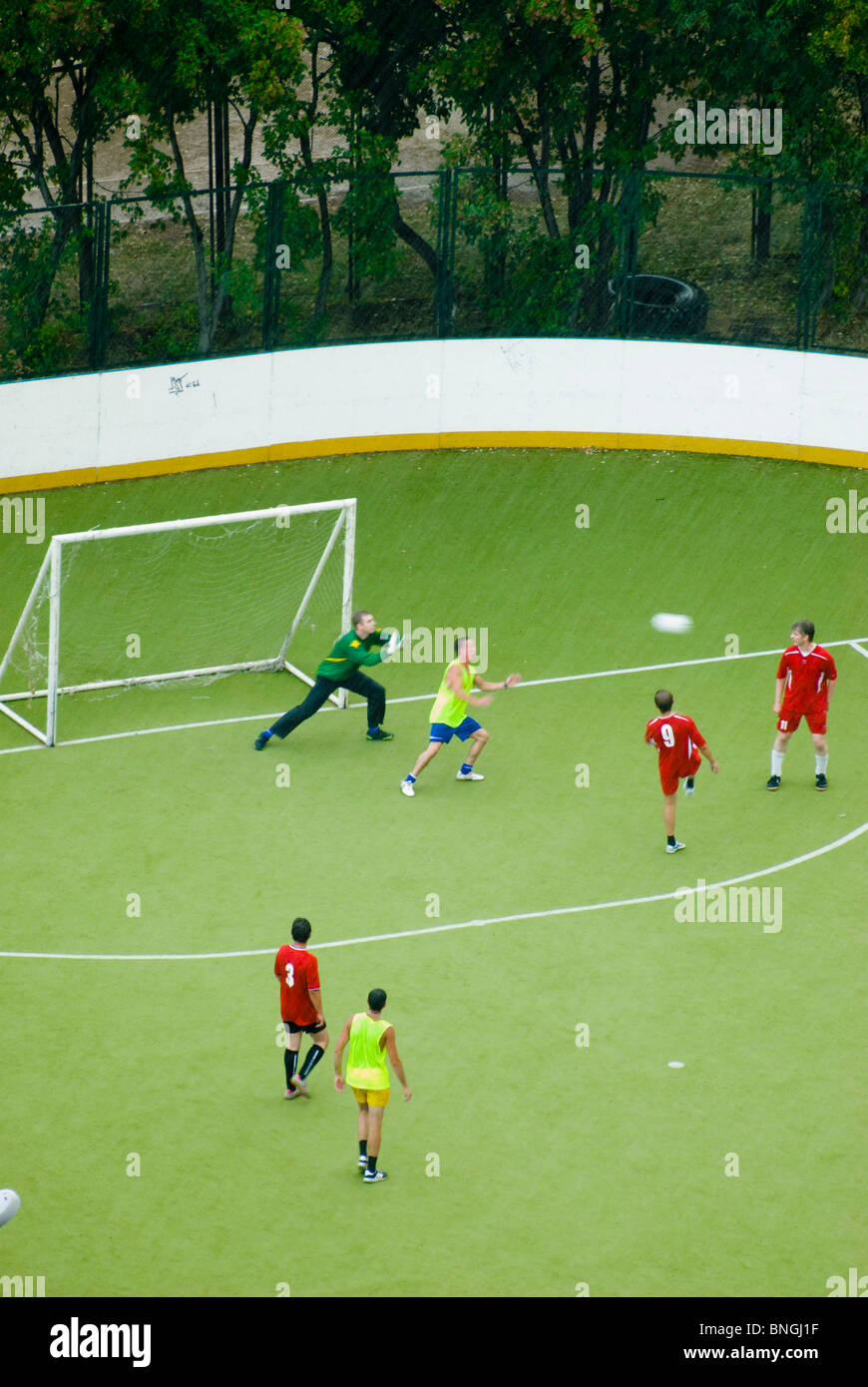 Adult men playing football under the rain Stock Photo - Alamy