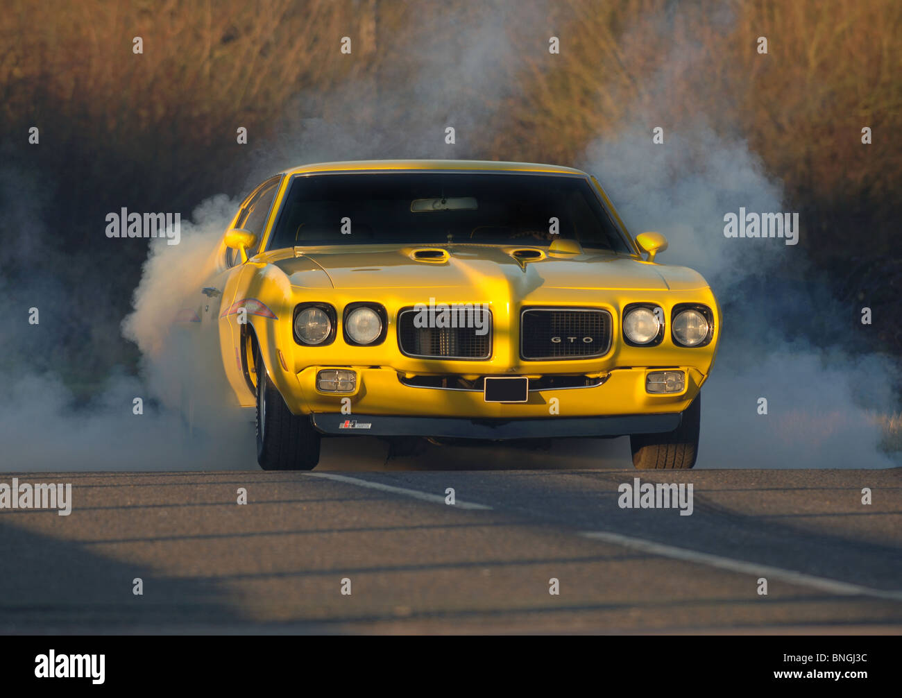 1970 Pontiac GTO muscle car doing a burn out in a cloud of tyre smoke ...