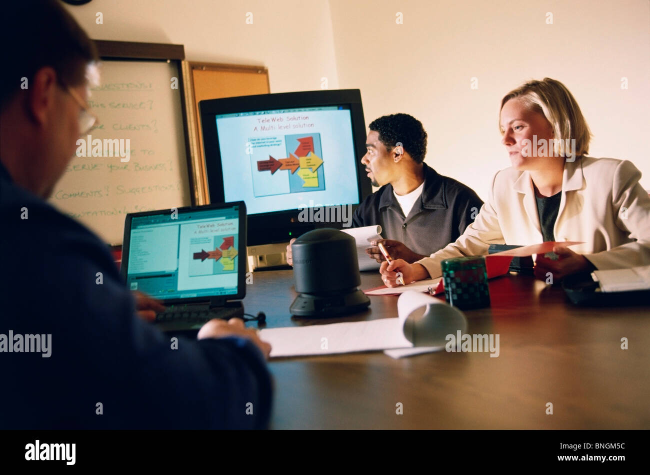 Business executives in a business meeting using computers in a ...