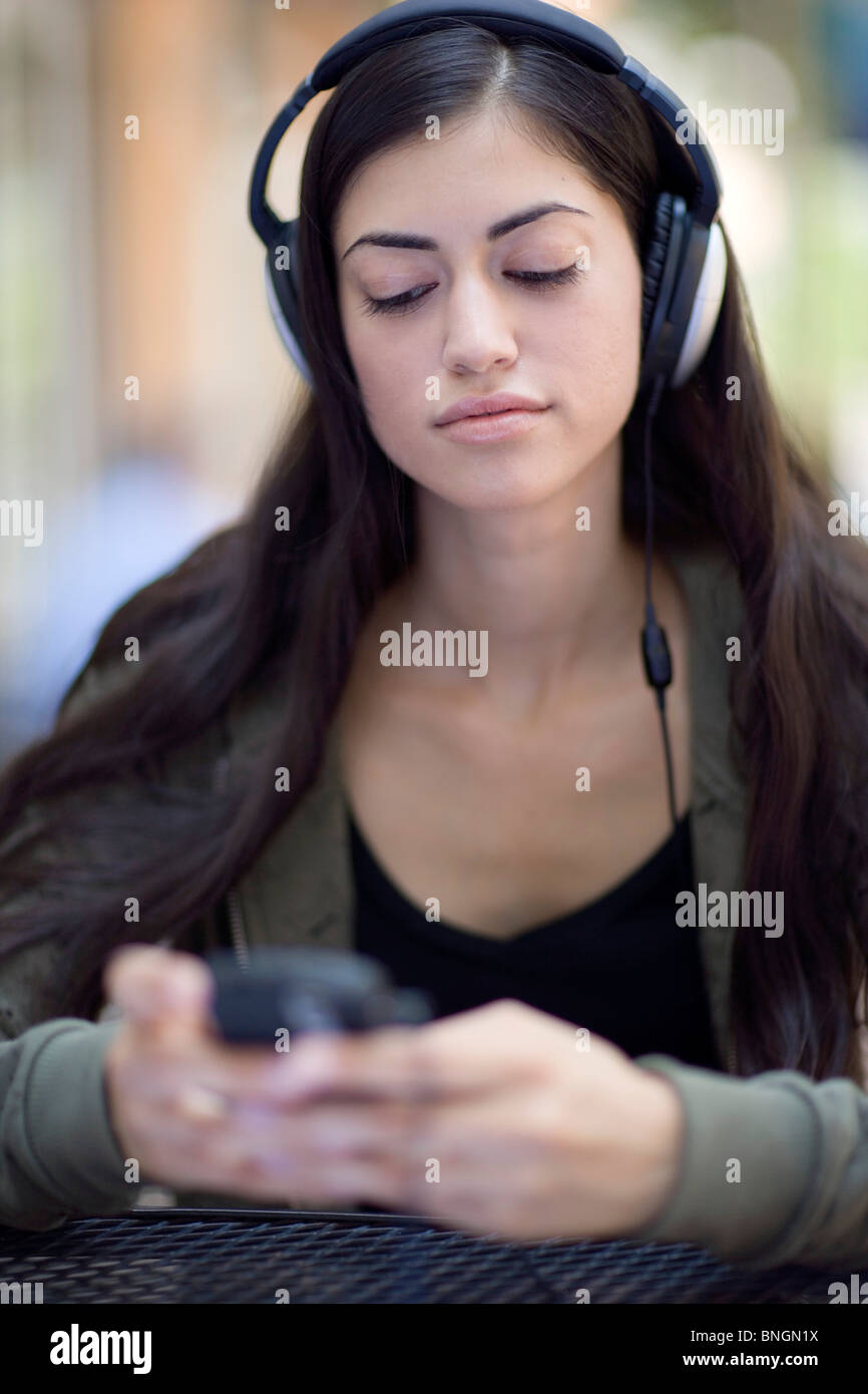Young woman listening to music on a mobile phone Stock Photo - Alamy