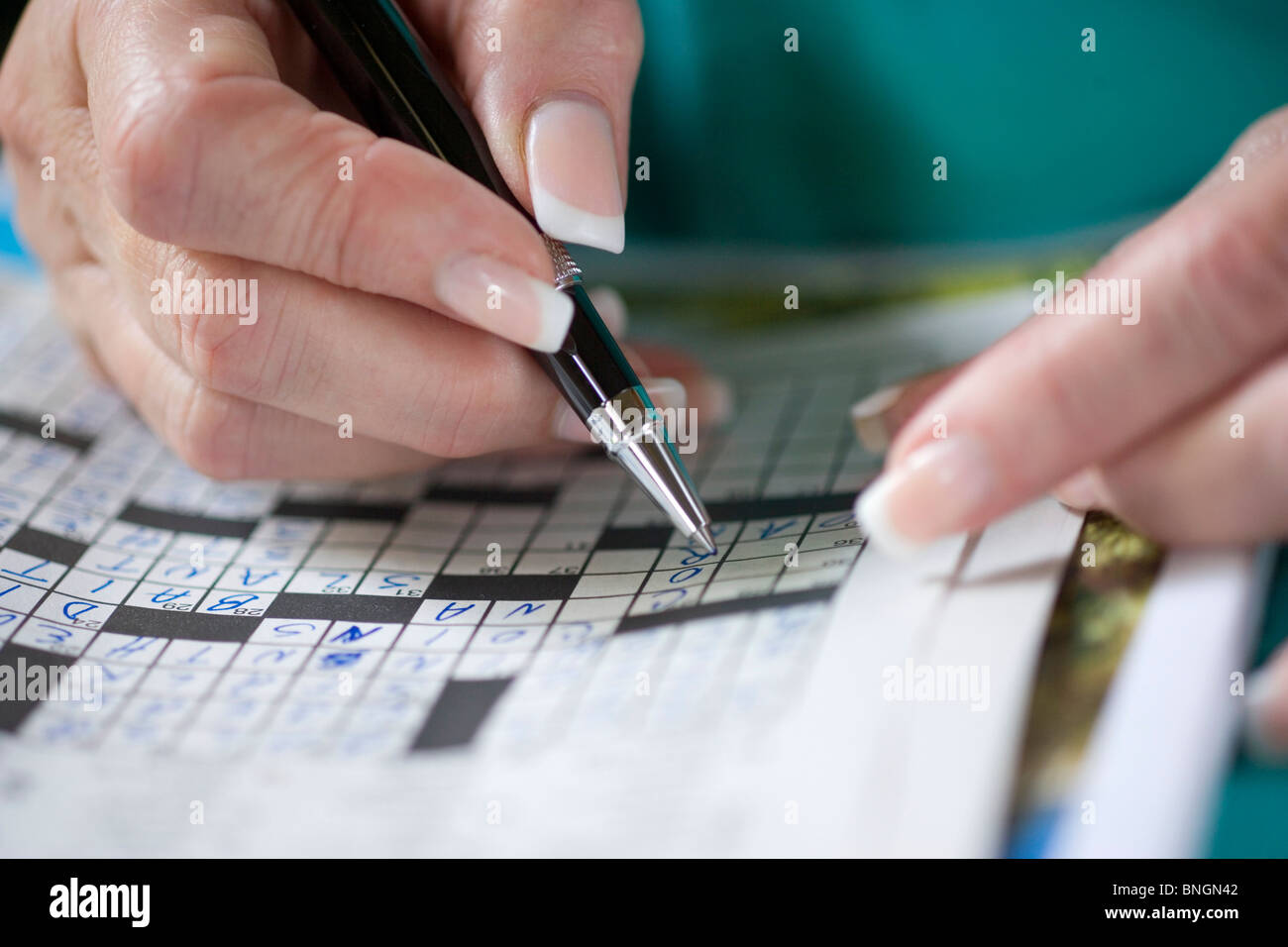Senior woman solving a crossword puzzle Stock Photo - Alamy