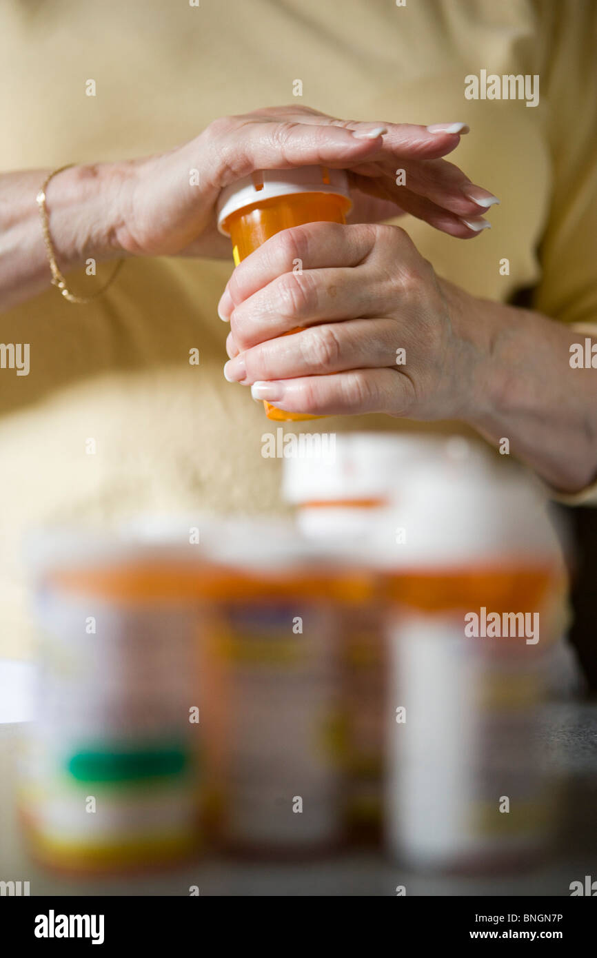 Elderly woman trying to open medication Stock Photo - Alamy