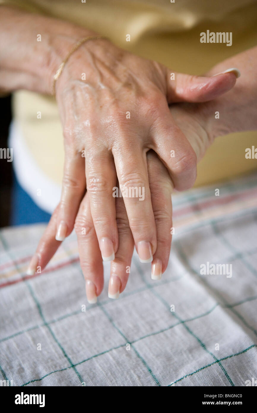Elderly woman trying to put on lotion Stock Photo - Alamy