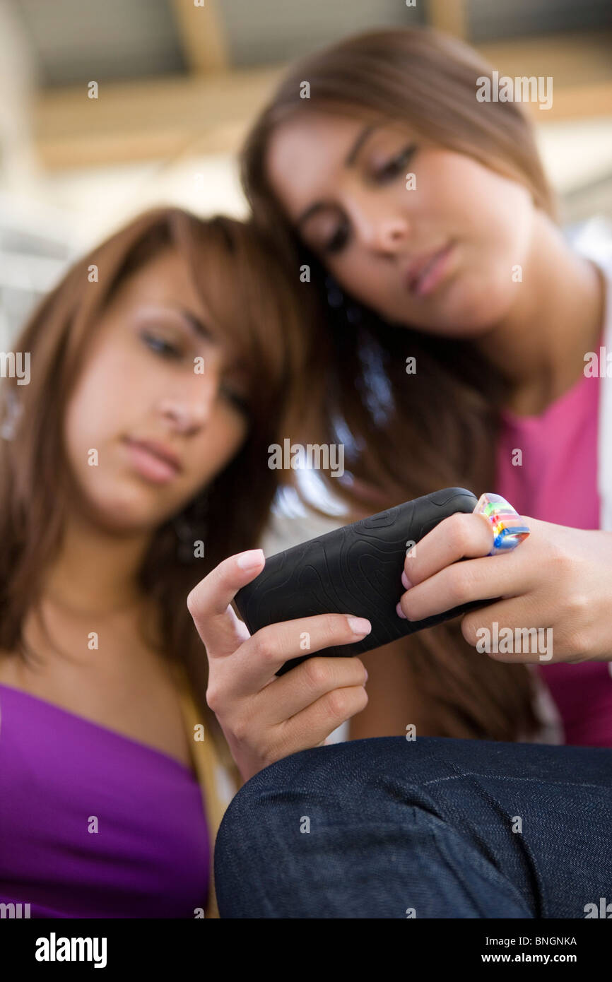 Teen girls using cell phone Stock Photo - Alamy