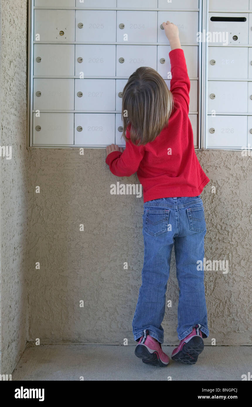 Girl reaching for mail in mailbox Stock Photo - Alamy