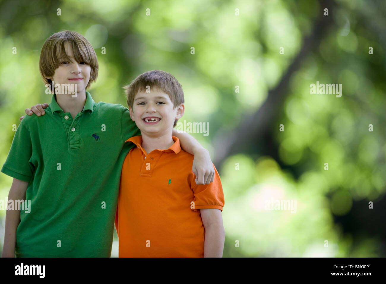 Two boys standing in a park and smiling Stock Photo - Alamy