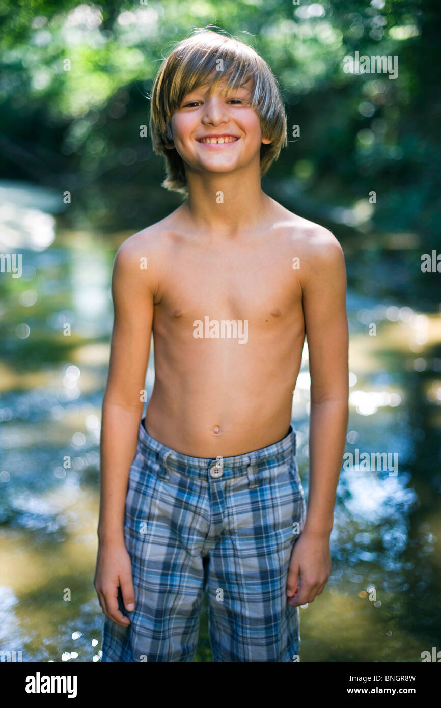 Portrait of boy standing near creek Stock Photo - Alamy