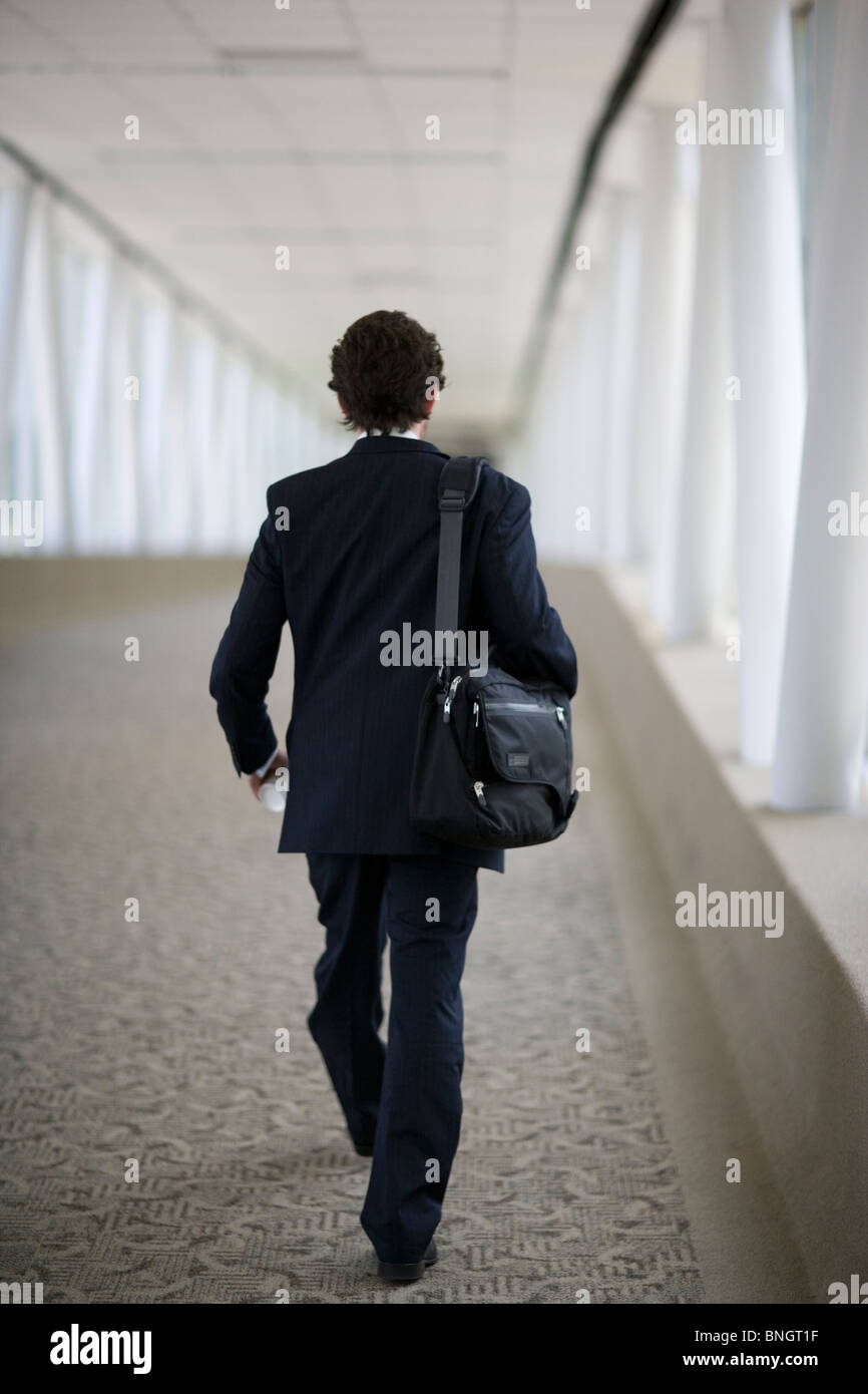 Businessman walking down corridor Stock Photo - Alamy