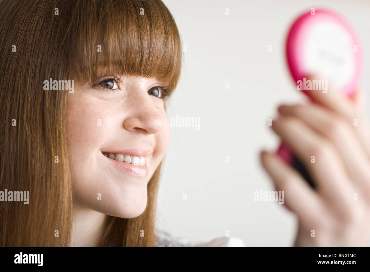 Young woman looking in a compact mirror Stock Photo - Alamy