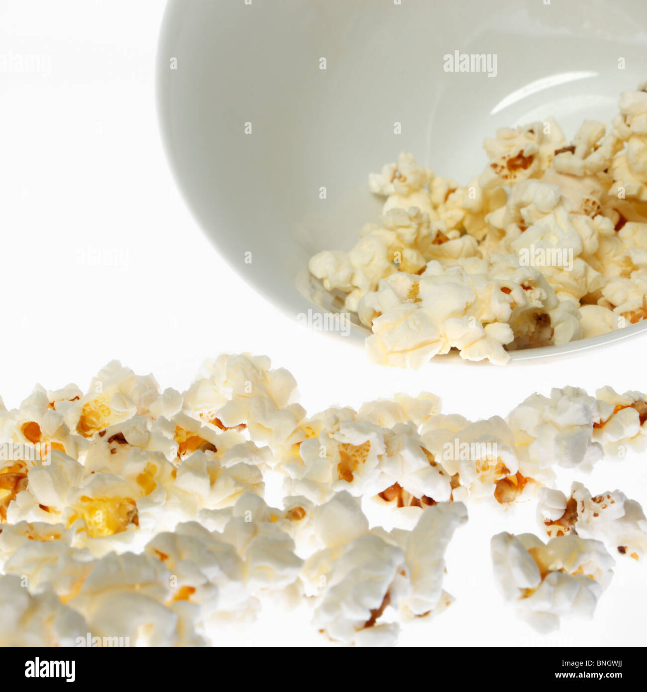 Popcorn falling out of a bowl Stock Photo - Alamy