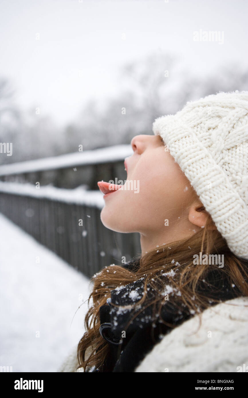 Girl catching snow on her tongue Stock Photo - Alamy