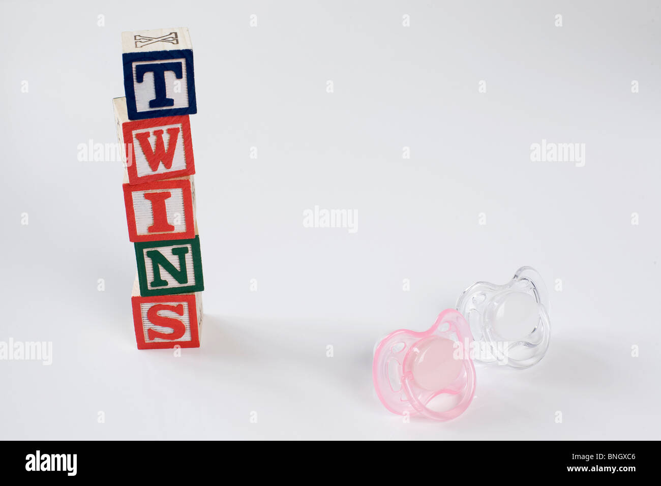Word TWINS made from stacked alphabetical blocks with two pacifiers ...