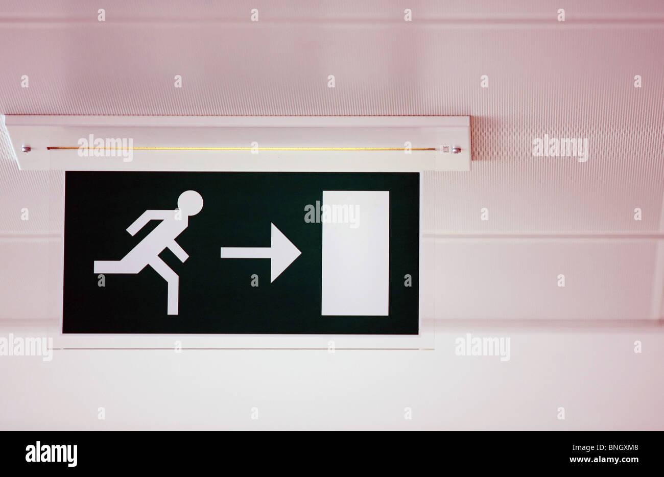 An emergency exit sign hanging from a ceiling Stock Photo - Alamy