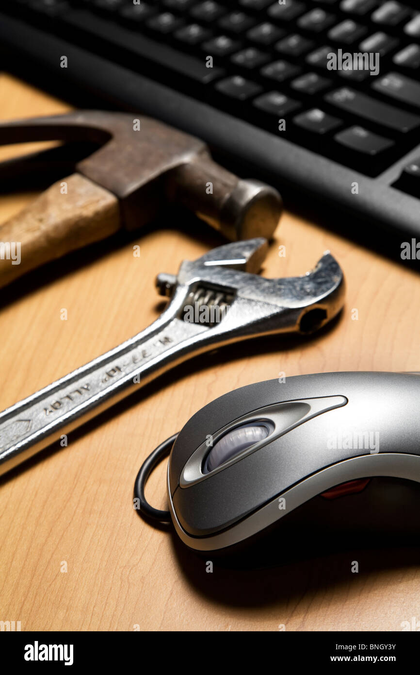 Metallic computer mouse, old tools placed next to compute keyboard ...