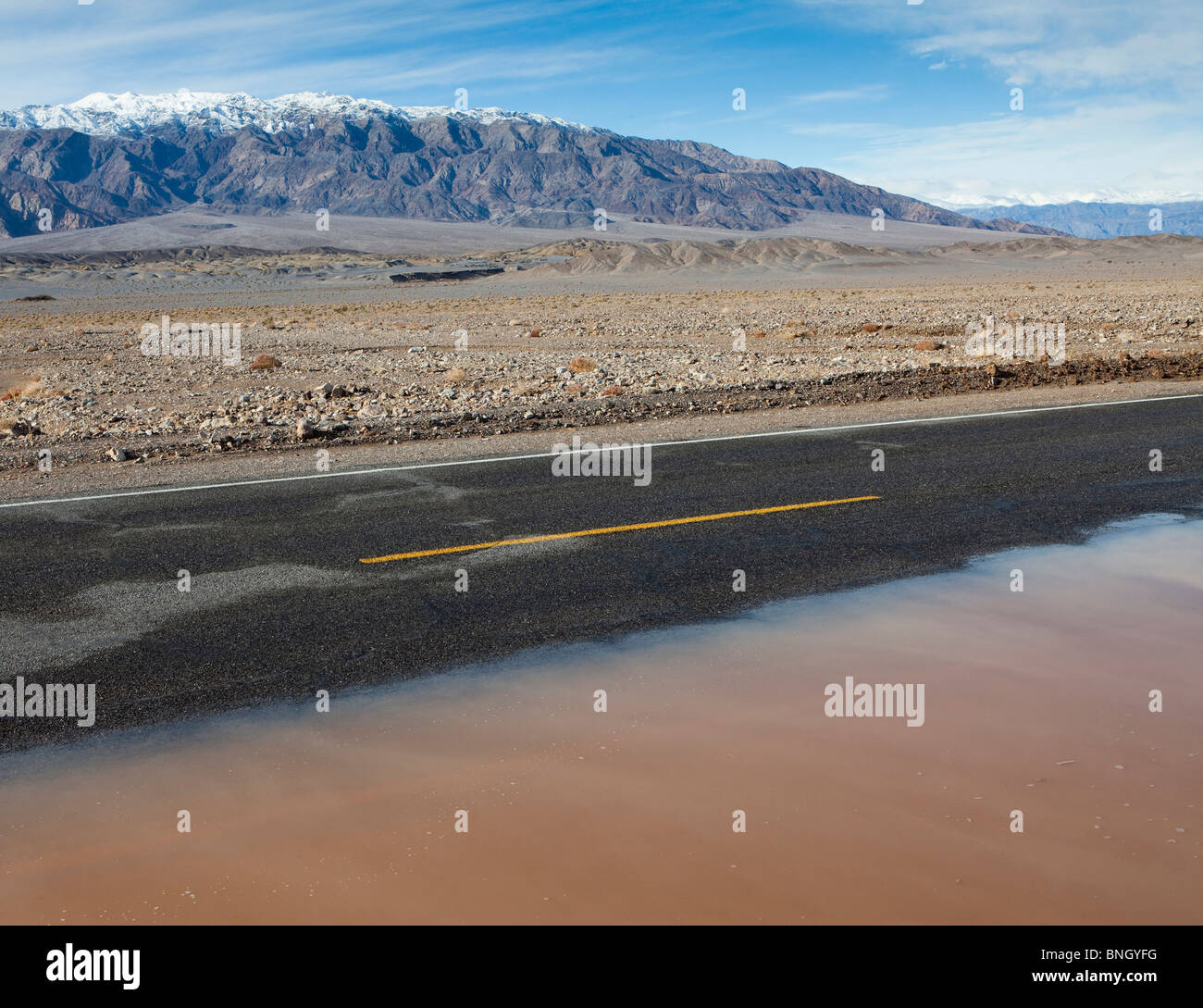 Flooded road passing through a desert, Death Valley National Park ...