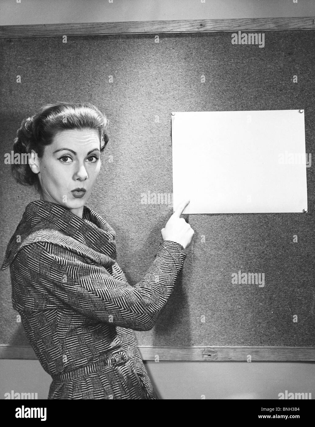 Portrait of a young woman pointing towards a paper Stock Photo - Alamy