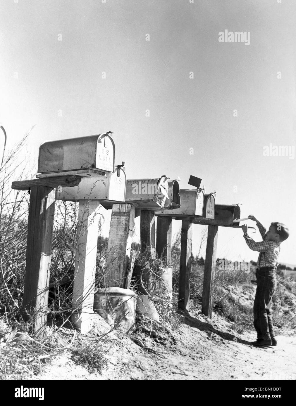 Boy taking mail from a mailbox Stock Photo - Alamy