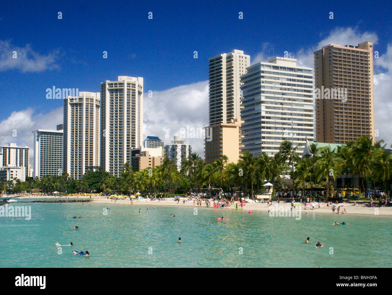 The Waikiki Beach in Oahu, Hawaii has white sand, palm trees, swimming ...