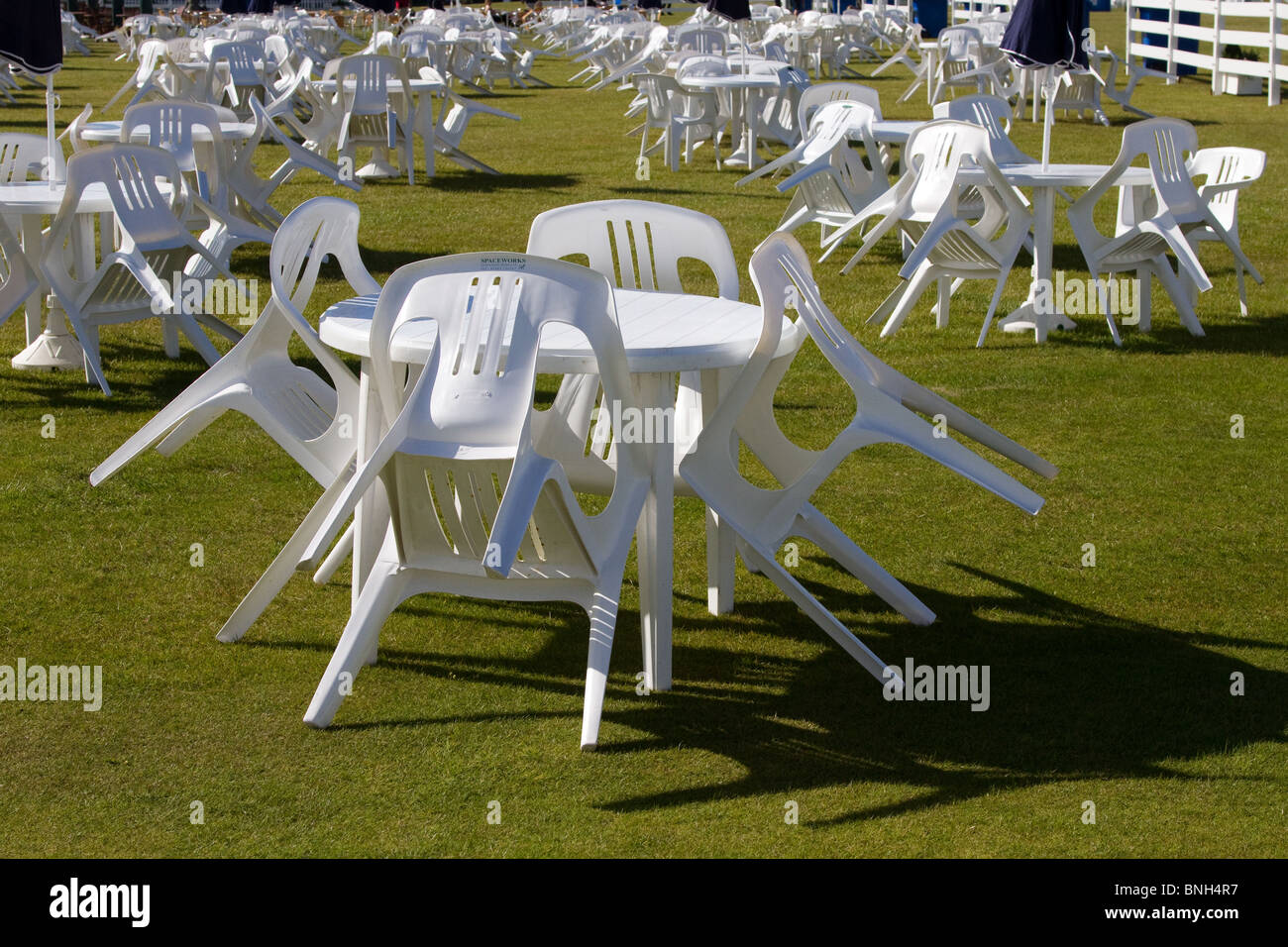 White plastic Tables and chairs upended, tilted up at the British Open ...