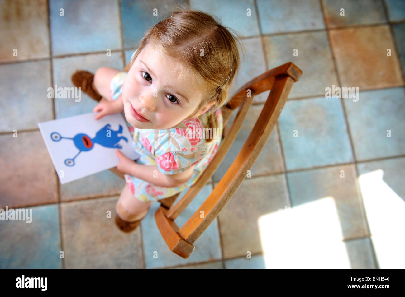 A three year old girl with a picture of the alien character Bic who is ...