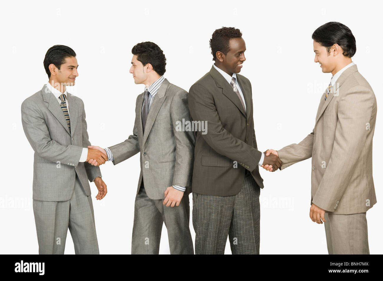 Four businessmen shaking hands Stock Photo - Alamy