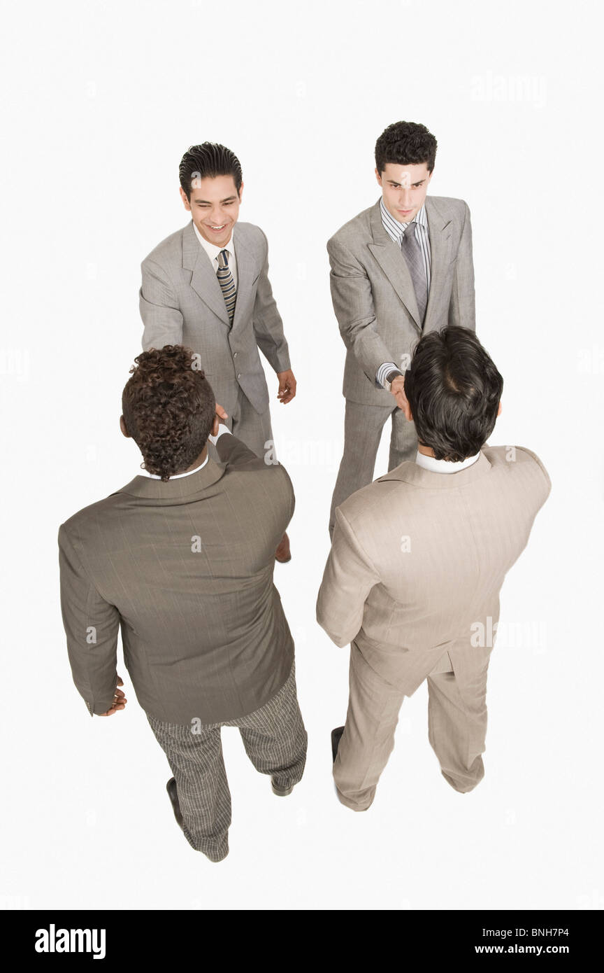 Four businessmen shaking hands Stock Photo - Alamy