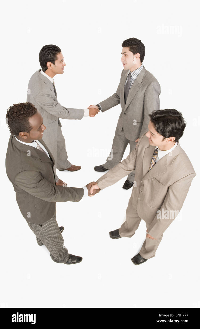 Four businessmen shaking hands Stock Photo - Alamy
