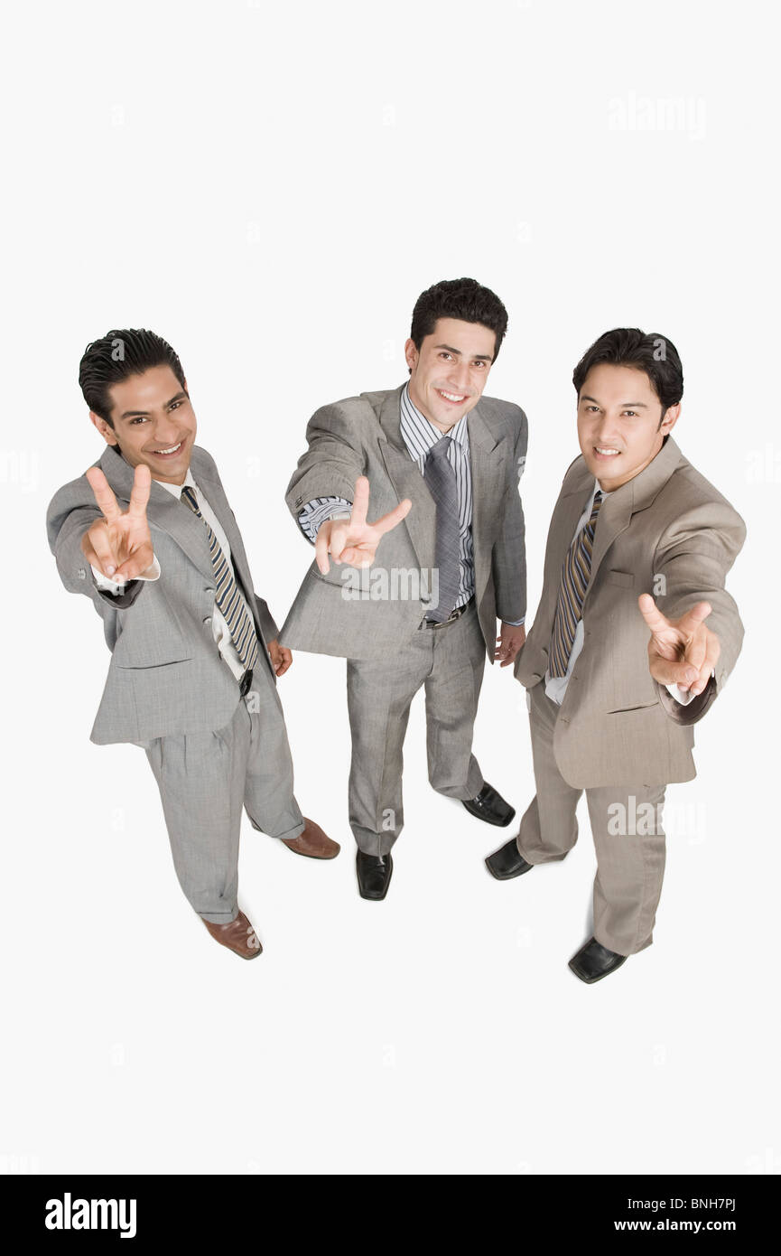 Portrait of three businessmen making peace signs Stock Photo - Alamy