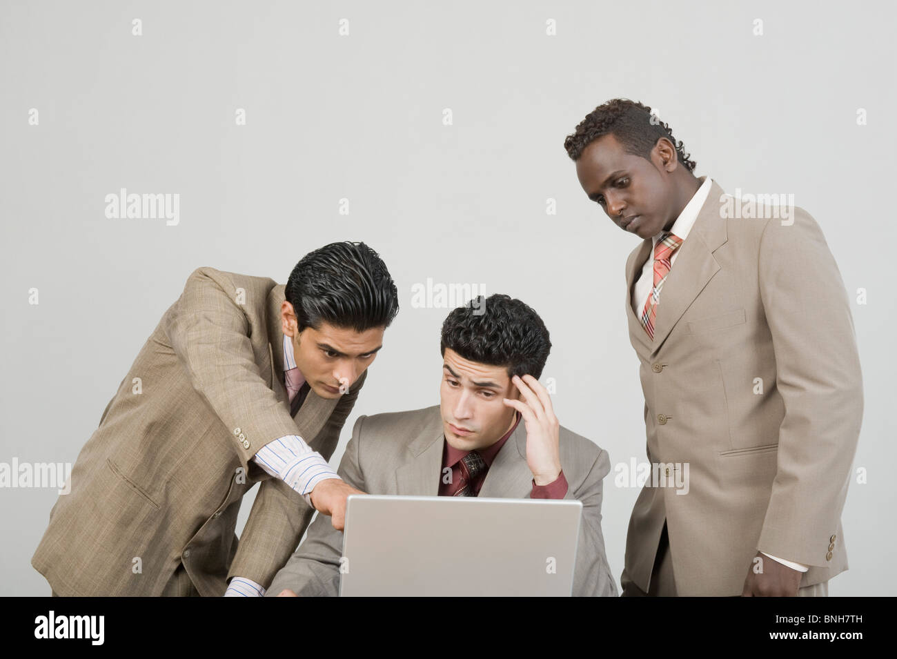 Three businessmen working on a laptop Stock Photo - Alamy