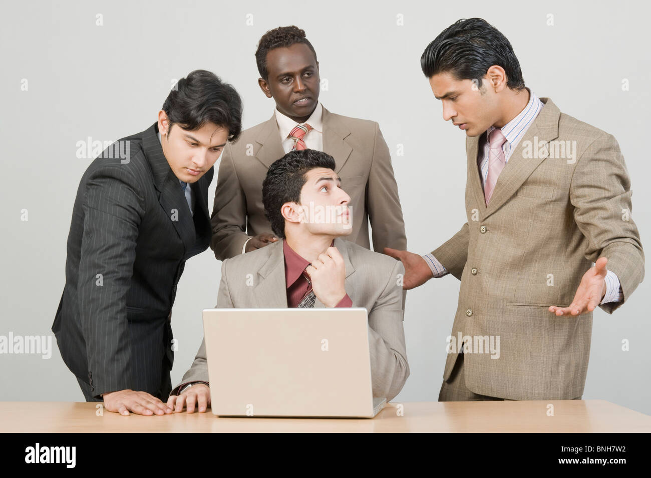 Four businessmen working on a laptop Stock Photo - Alamy Four businessmen working on a laptop Stock Photo - Alamy