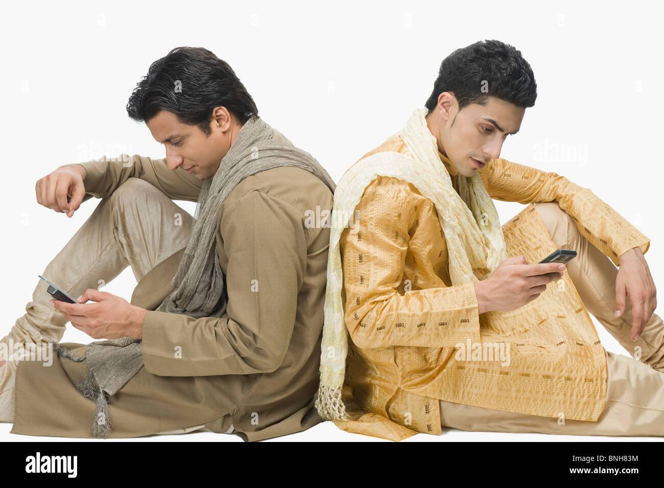 Two men text messaging on mobile phones Stock Photo - Alamy