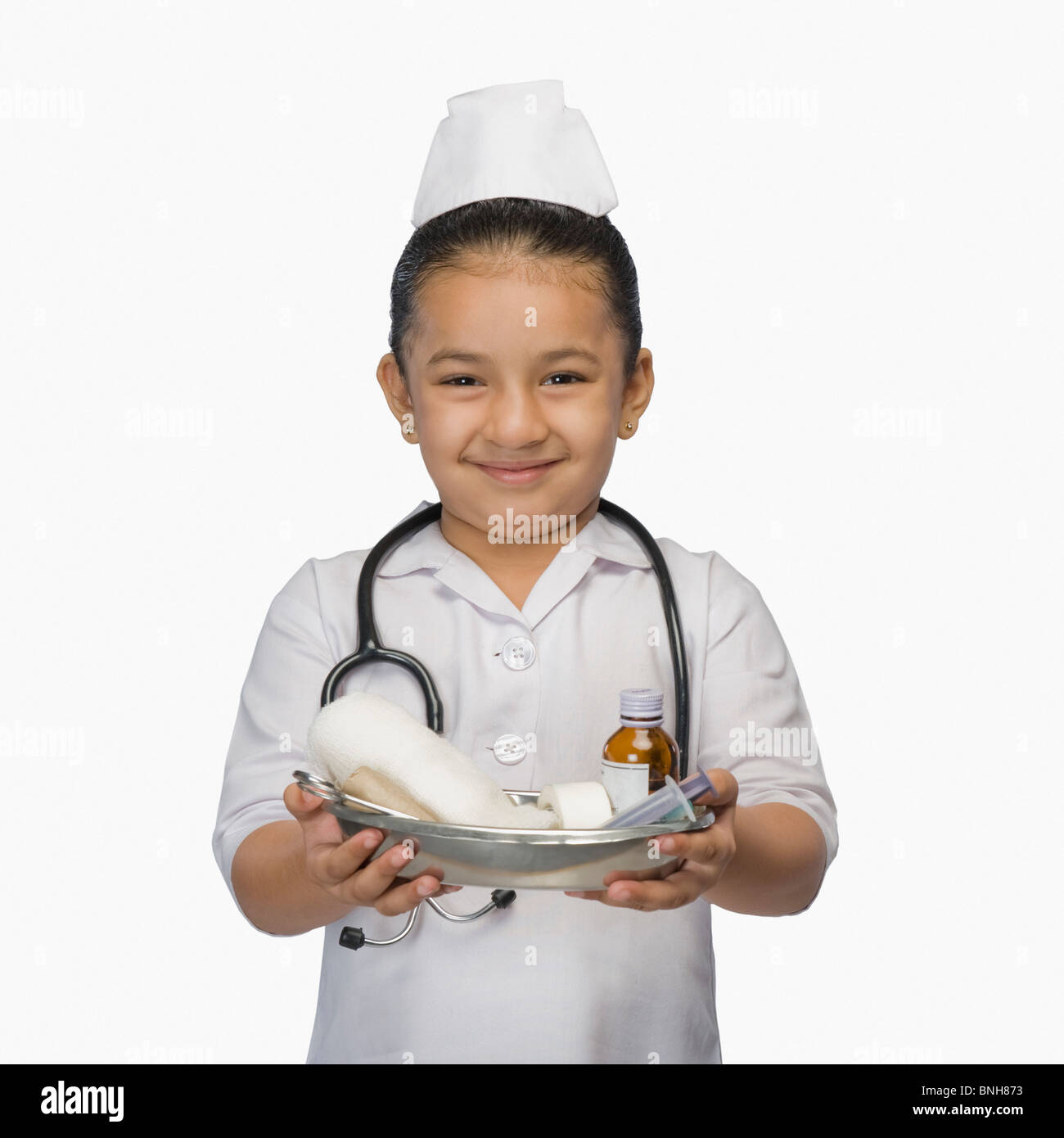 Girl dressed as a nurse and holding a tray of medicines and smiling ...