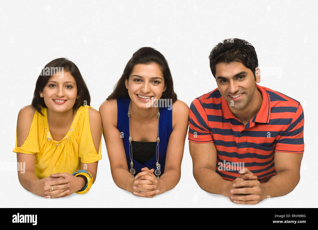 Portrait of three friends lying side by side and smiling Stock Photo ...