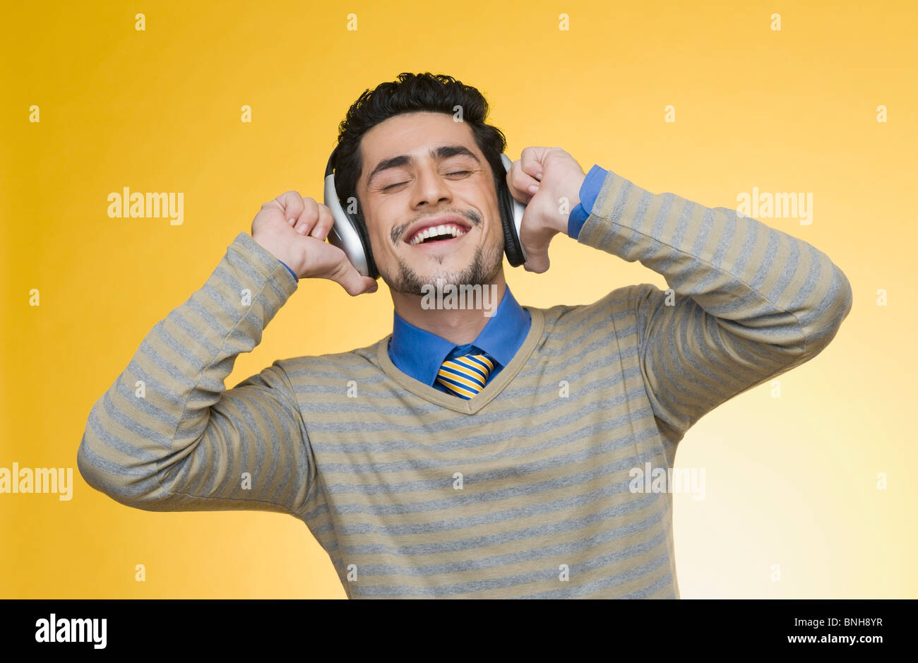 Businessman listening to headphones Stock Photo - Alamy