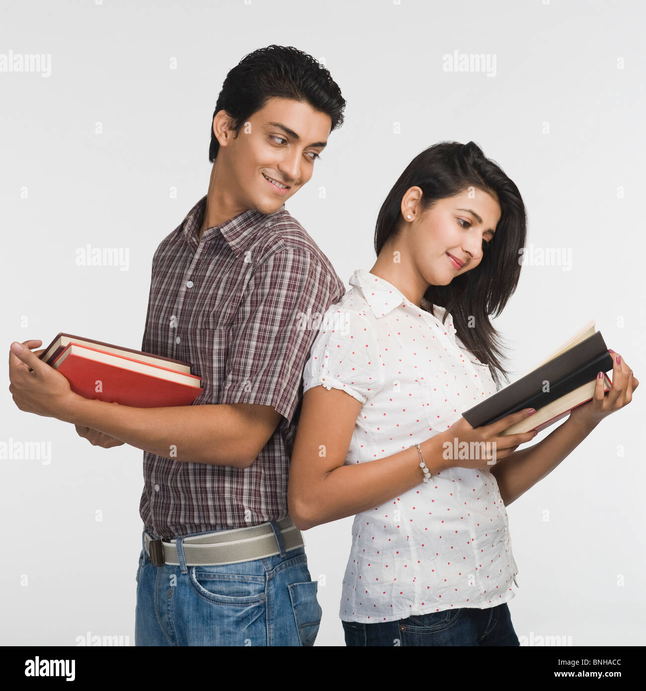 College students standing back to back and reading books Stock Photo ...