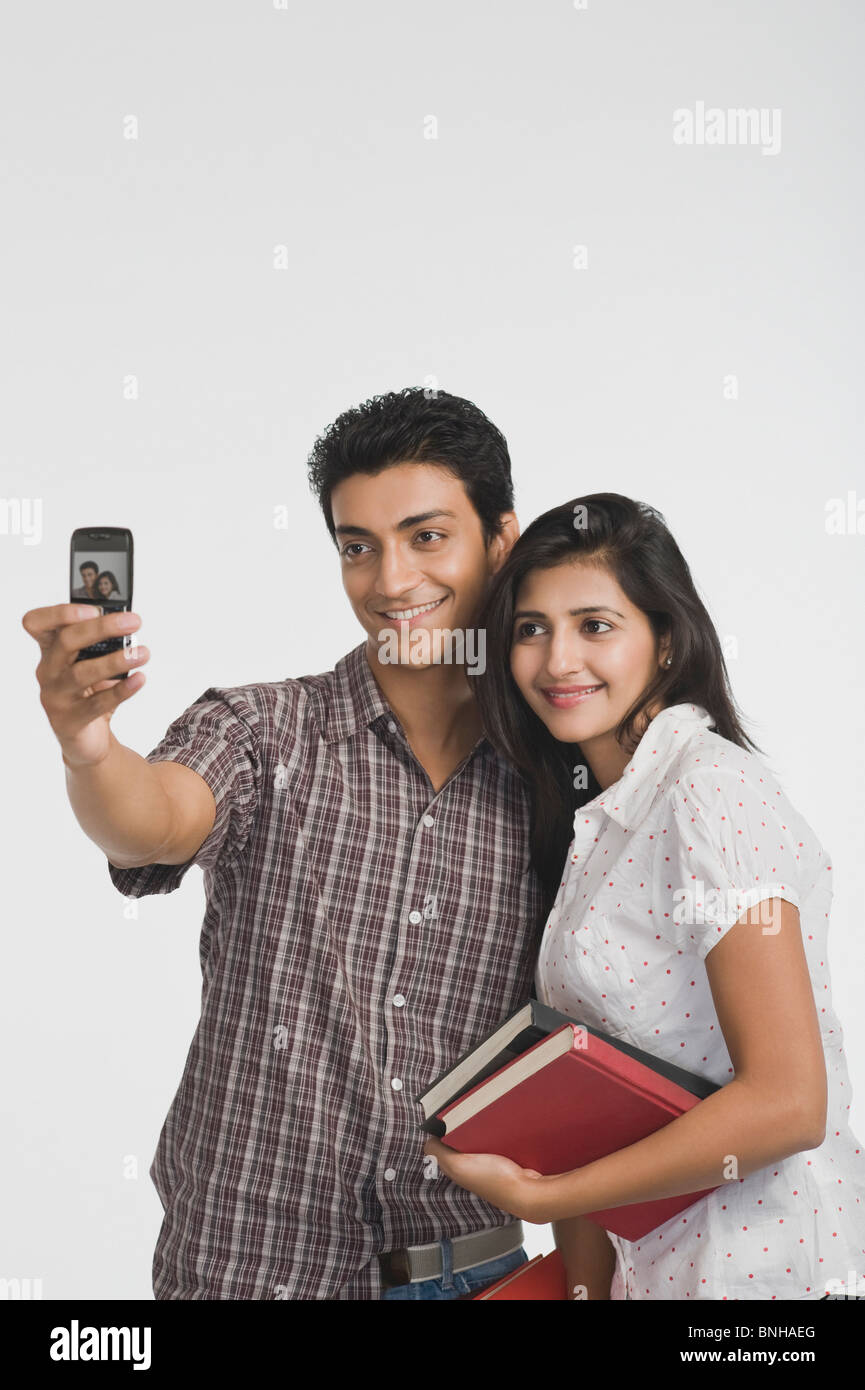 College students taking a picture of themselves with a camera mobile ...