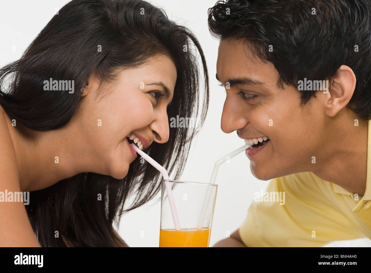 Couple sharing juice from a glass Stock Photo - Alamy